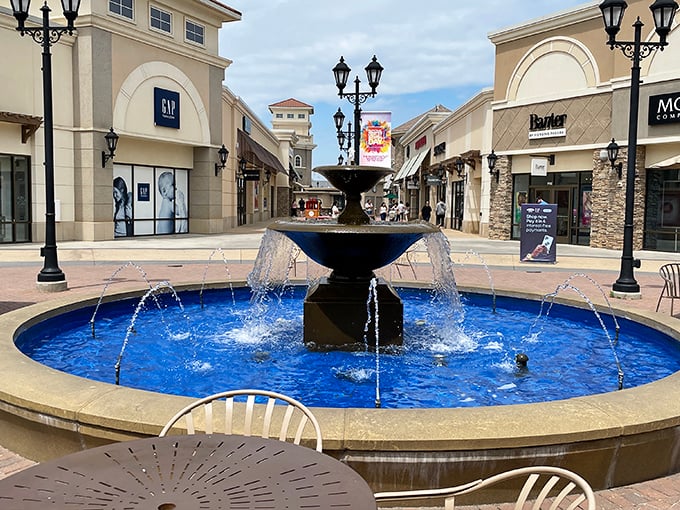 The blue fountain centerpiece—where wishes are tossed for designer finds at outlet prices, and tired feet get a moment's reprieve.
