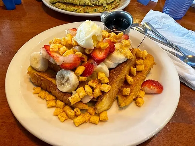 French toast that's dressed for success, topped with fresh fruit and what appears to be Captain Crunch—breakfast cereal making a cameo as a topping star.