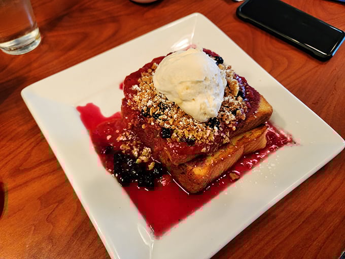 French toast that's dressed for success in berry coulis and streusel crumble—breakfast masquerading as dessert, and nobody's complaining.