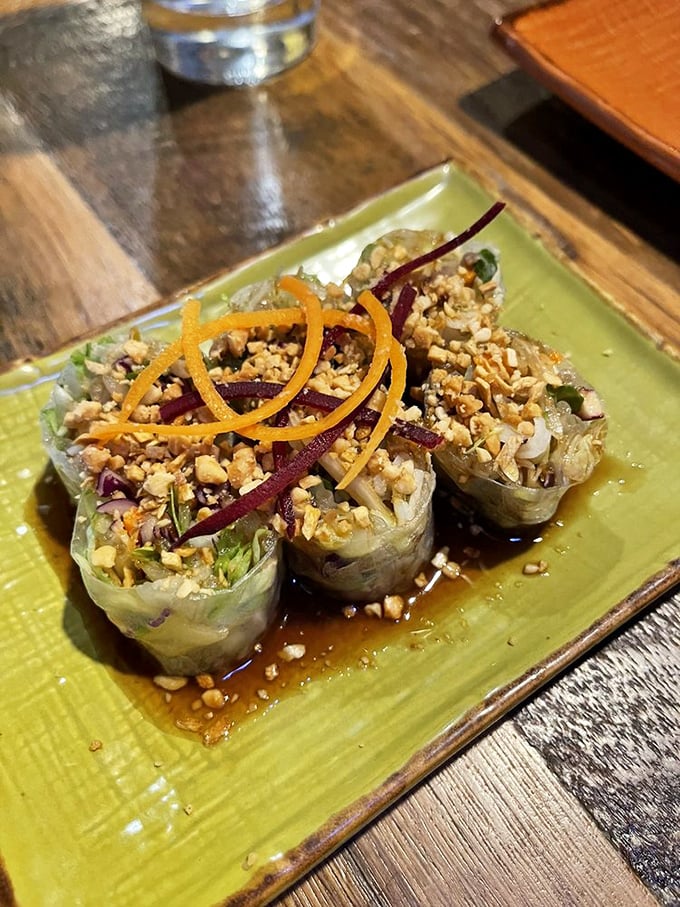 Fresh spring rolls that look like edible jewel boxes, topped with crushed peanuts and julienned vegetables. Transparency in food form—what you see is what you get.
