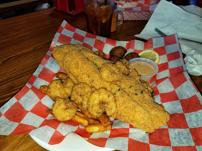Cornmeal-crusted catfish and shrimp served on checkered paper—proof that the best Southern comfort doesn't need fancy china to change your life.