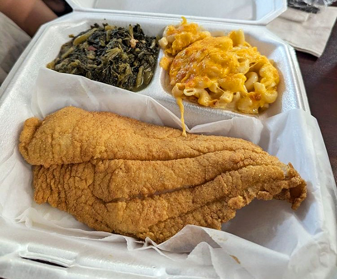 The holy trinity of Southern eating: perfectly fried catfish, collard greens, and mac and cheese that pulls like it's auditioning for a cheese commercial.
