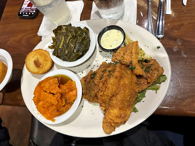 Fried catfish done right – golden armor protecting flaky treasure, with sides that deserve their own spotlight moment.