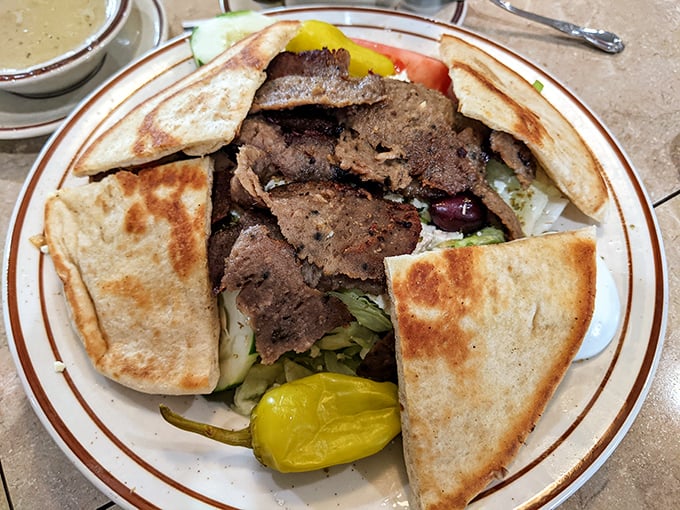 This gyro plate isn't just lunch—it's a Mediterranean vacation for your taste buds, complete with pita bread beach umbrellas and pickle garnish palm trees.