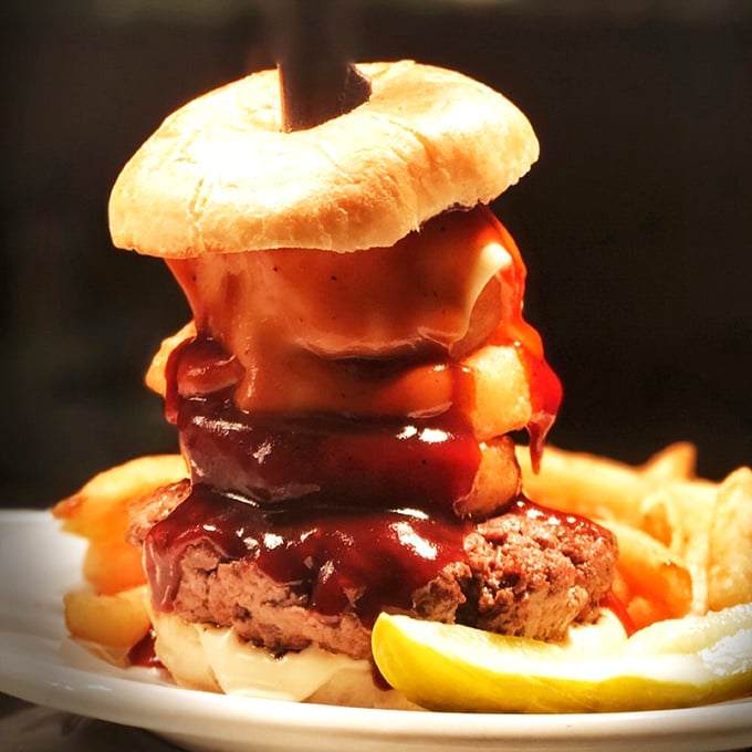 This isn't just a burger – it's a towering achievement of beef, cheese, and BBQ sauce that makes you wonder if you should unhinge your jaw like a snake.