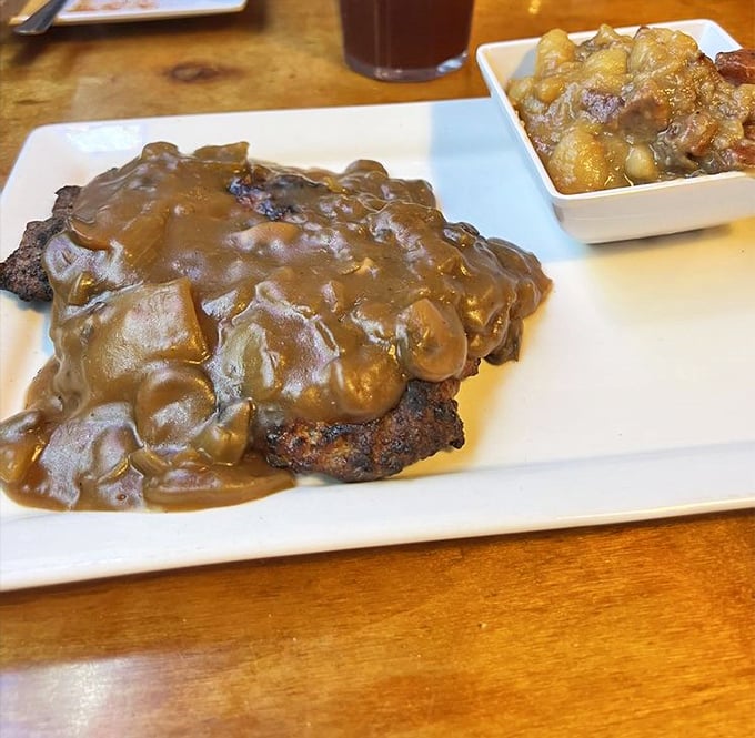 Hamburger steak swimming in mushroom gravy—comfort food that whispers, "Everything's going to be alright" with every savory bite.
