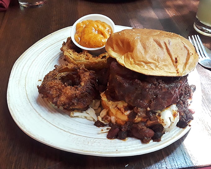 A burger so substantial it deserves its own zip code. That onion ring perched on top isn't garnish—it's the crown jewel.