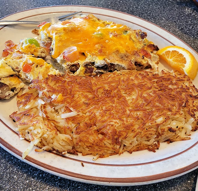 Crispy hash browns that crackle with each bite meet a cheese-blanketed omelet. This plate doesn't just serve breakfast—it celebrates it.