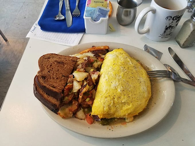 This omelet doesn't just come with hash browns—it's a complete breakfast ecosystem with perfectly toasted bread standing guard.