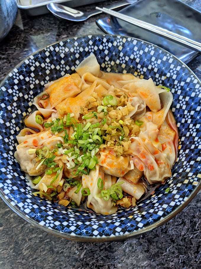 Plump wontons nestled in chili oil like little flavor bombs waiting to detonate. The scallions aren't garnish—they're essential supporting actors.