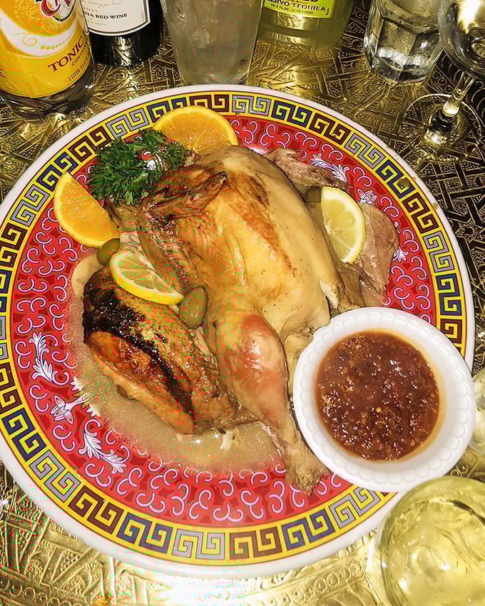 Golden chicken that's traveled through a flavor passport of lemon, olives, and mysterious spices—served with a side of sauce that demands to be sopped up with bread.