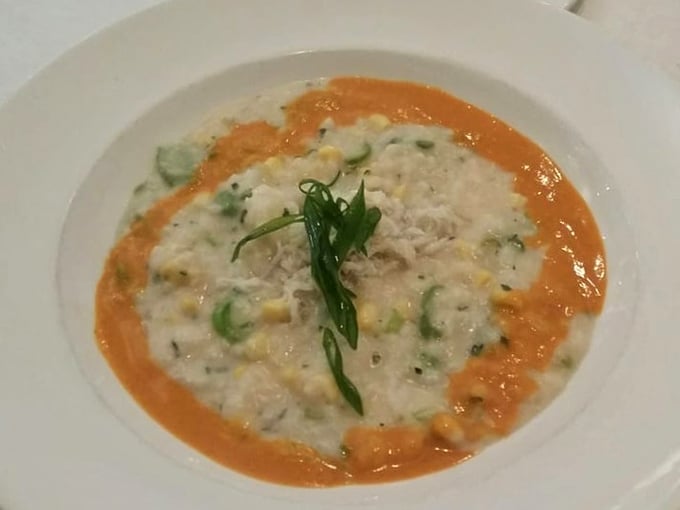 A bowl of comfort disguised as culinary art—creamy risotto cradles tender crab while the vibrant sauce creates a sunset on your plate.