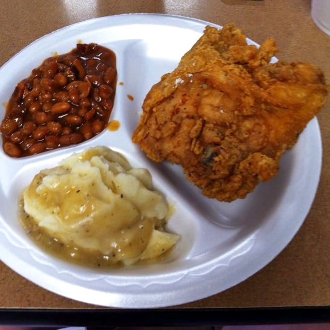 Baked beans and mashed potatoes flanking that legendary chicken—a Southern trinity that proves heaven exists and it's on this very plate.