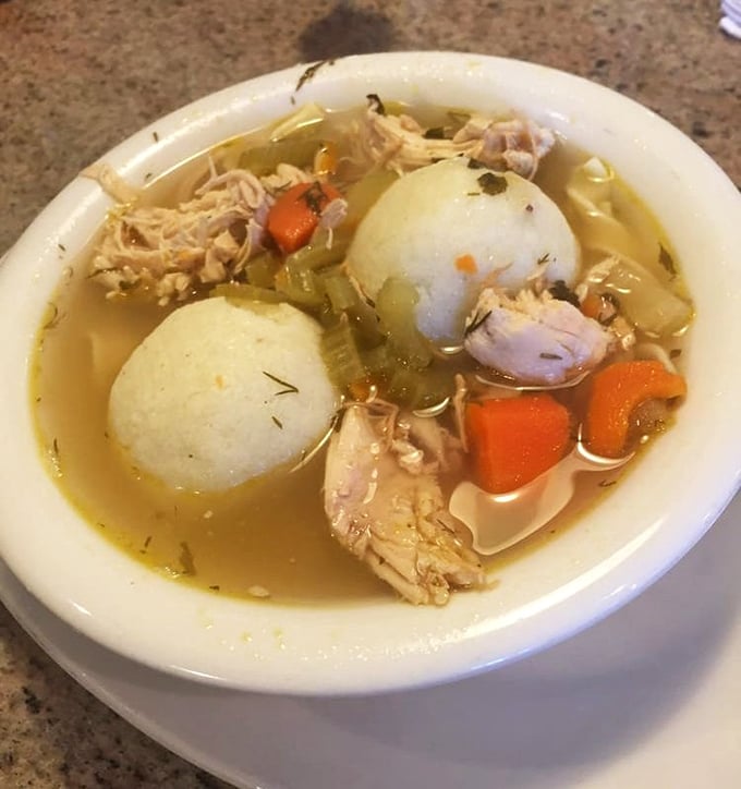 The matzo ball soup arrives like a warm hug in bowl form—golden broth, tender chicken, and matzo balls that would make any bubbe proud.