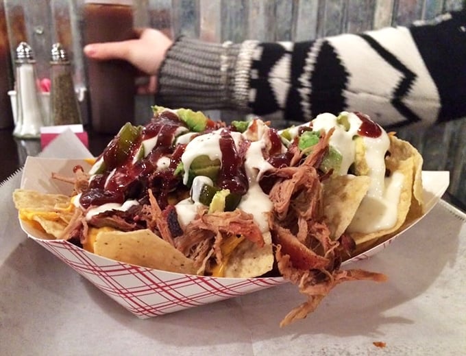 These nachos aren't just loaded—they're having an existential crisis under the weight of all that pulled pork, sauce, and jalapeños. Worth every messy bite.