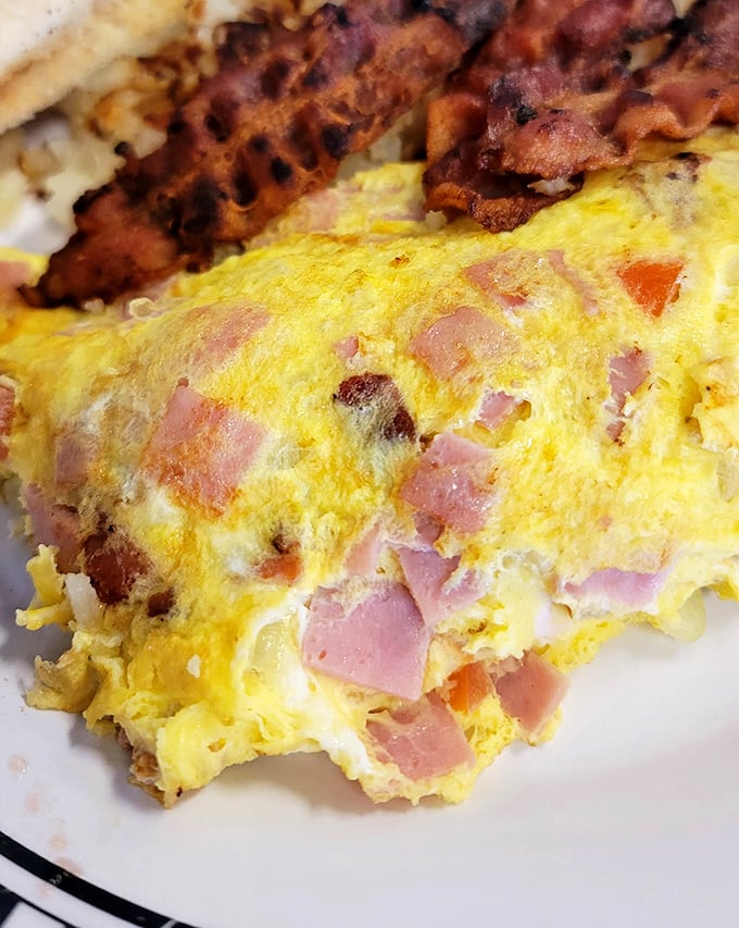 This isn't just an omelet—it's a masterpiece of ham and cheese architecture that makes you question why you ever eat anything else.