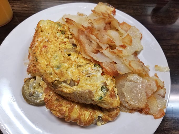This isn't just an omelet – it's a golden-hued masterpiece with a supporting cast of perfectly crisped home fries.