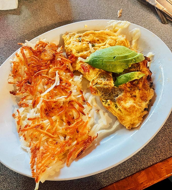 This omelet doesn't just come with hash browns and avocado—it arrives with the confidence of something that knows it's about to make your day.