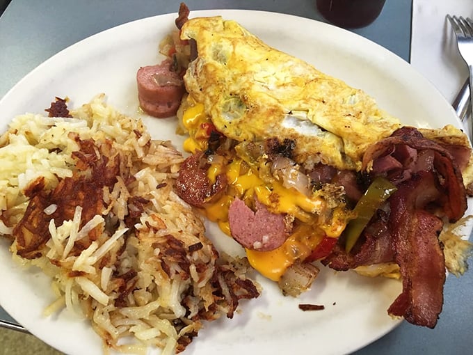 This isn't just an omelet—it's a treasure chest of breakfast jewels with perfectly crisped hash browns standing guard on the side.