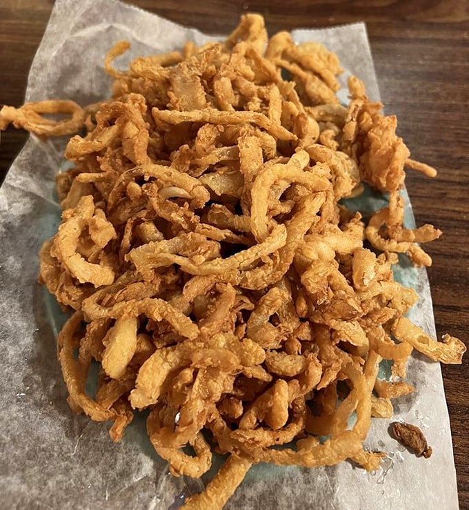 These onion strings aren't just a side dish; they're a crispy, golden tangle of happiness that demands to be shared—or hoarded.