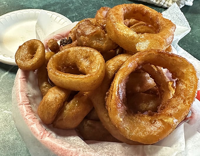 Golden, crispy onion rings stacked like delicious life preservers, ready to rescue you from the sea of ordinary side dishes.