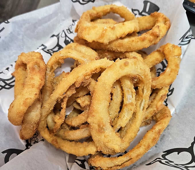 Onion rings that shatter with geological precision – crispy armor protecting sweet, tender onion within. The perfect supporting actor to any barbecue star.