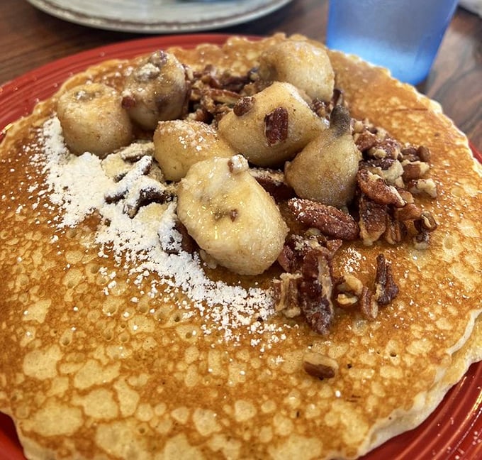 This isn't just a pancake—it's a throne for caramelized bananas and pecans, dusted with powdered sugar. Breakfast royalty at its finest.