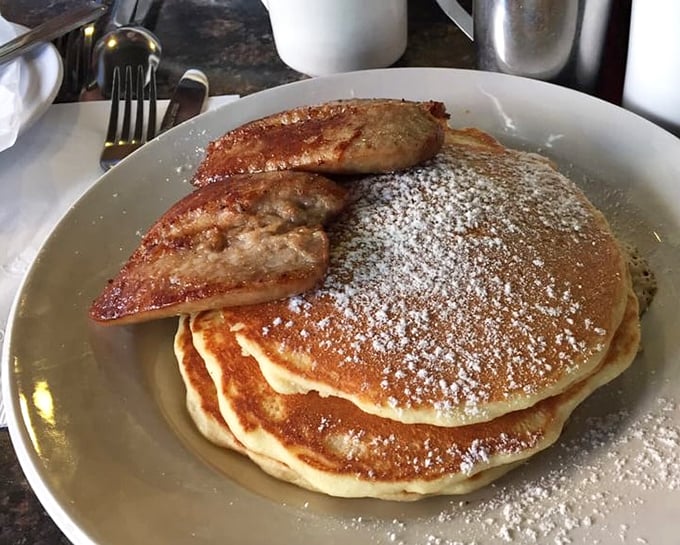 Pancakes so fluffy they could double as pillows, dusted with powdered sugar and accompanied by sausage links that mean business.