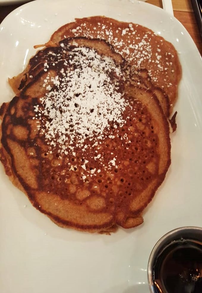 This pancake isn't just cooked—it's been sweet-talked to golden-brown perfection. The powdered sugar snowfall is just showing off at this point.