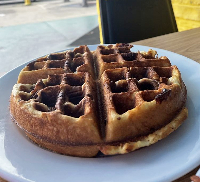 This waffle isn't just breakfast – it's architecture with purpose, each square pocket perfectly designed to hold maximum syrup capacity.