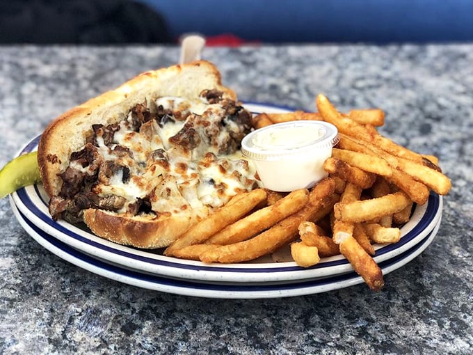 The Philly sandwich arrives open-faced and proud, with melted cheese blanketing seasoned meat like a delicious winter comforter.