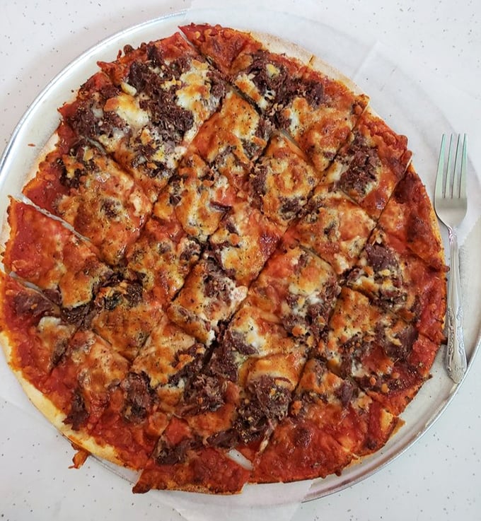 Chicago thin crust perfection in its natural habitat—crispy, square-cut, and topped with sausage that means business.