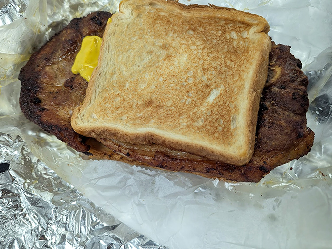 The sandwich that launched a thousand road trips—perfectly toasted bread embracing a pork chop that means serious business.