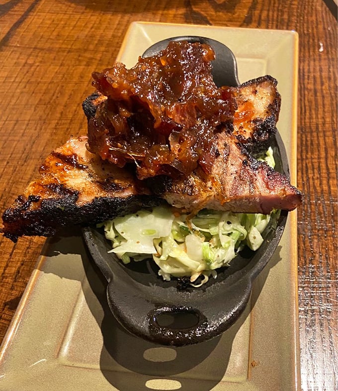 Pork belly perched atop fresh slaw – a study in contrasts where smoky richness meets crisp vegetables in perfect harmony.