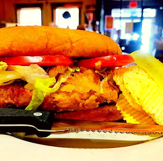 This isn't just a pork chop sandwich; it's an architectural marvel of crispy fried goodness, fresh veggies, and the kind of bread that makes carb-counting seem like a crime.