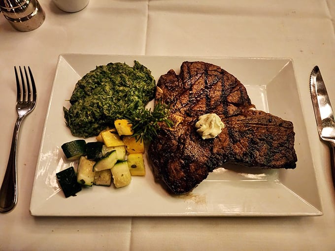 The porterhouse arrives like a meaty masterpiece – part filet, part strip, all delicious – with creamed spinach that puts steakhouse side dishes in the spotlight where they belong.