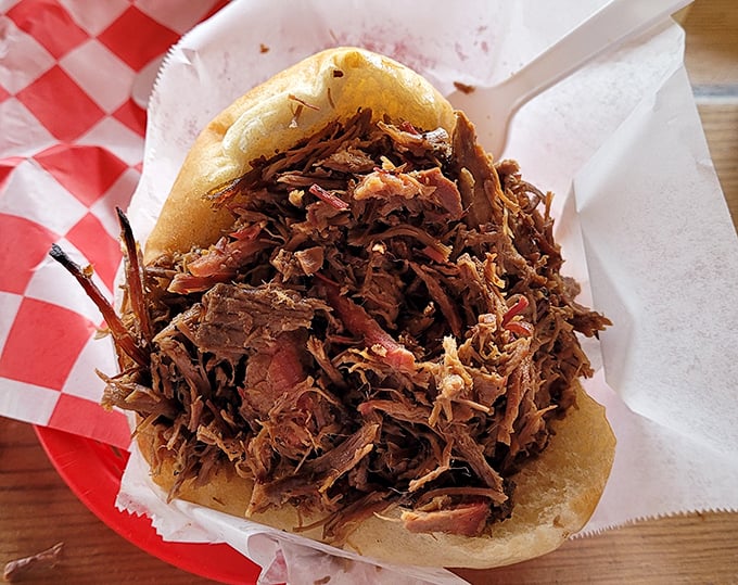 This pulled pork sandwich isn't just a meal—it's an edible hug. The bun barely containing its smoky, juicy contents like a parent trying to wrangle an enthusiastic toddler.