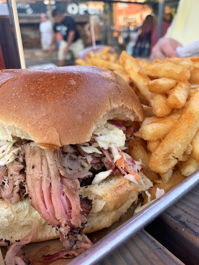 This pulled pork sandwich isn't just a meal – it's an architectural marvel of tender meat, tangy slaw, and a bun struggling heroically to contain it all.