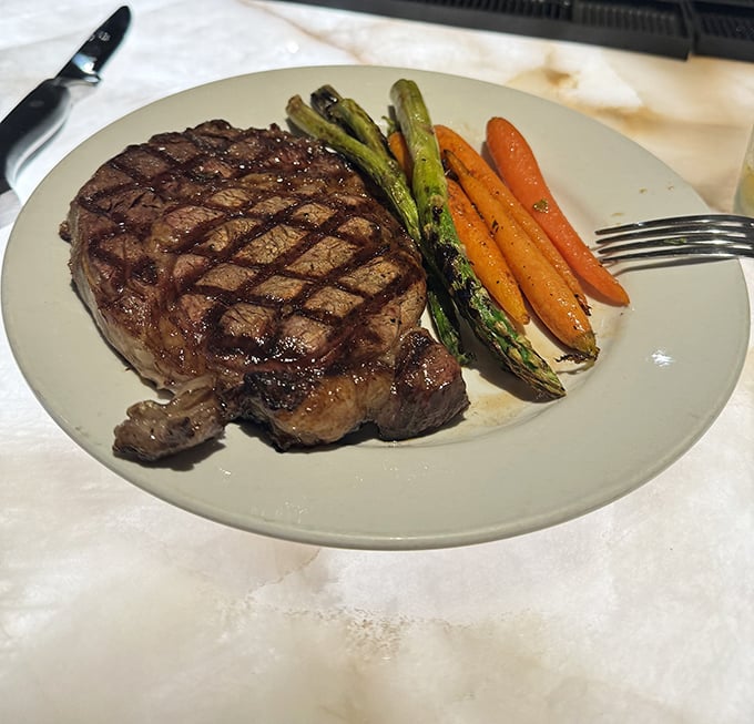 This ribeye's perfect grill marks aren't just for show – they're a roadmap to flavor country, with au jus that deserves its own fan club.
