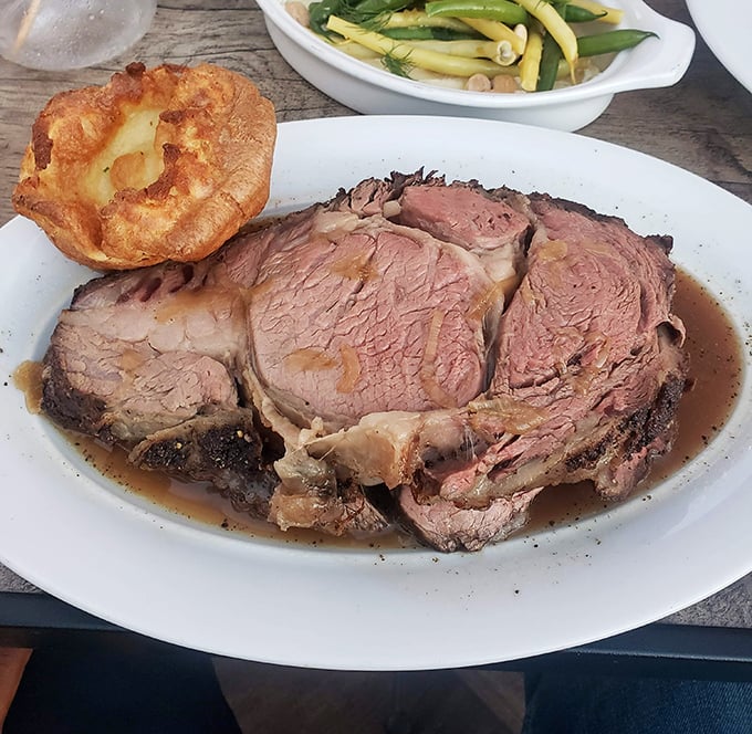 The prime rib at Golden Bull arrives like a carnivore's dream – perfectly pink, swimming in savory jus, with that Yorkshire pudding standing tall like a proud sidekick.