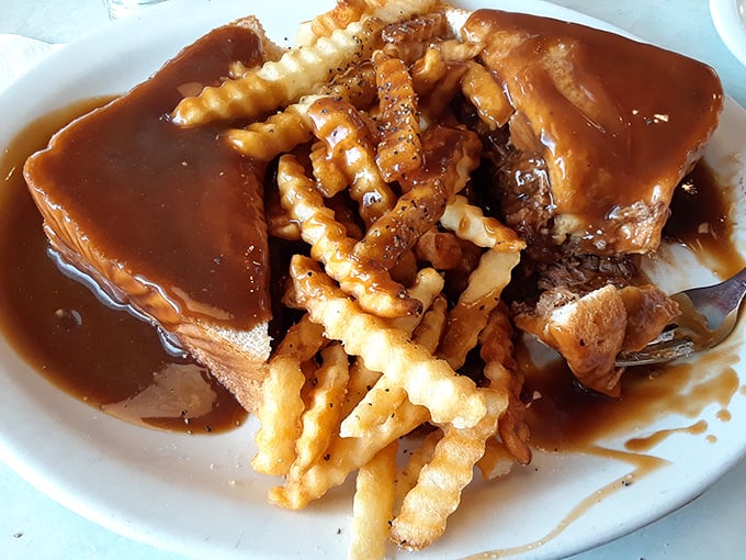 Comfort food doesn't get more comforting than this – a tender pot roast swimming in rich gravy alongside crispy fries that deserve their own fan club.