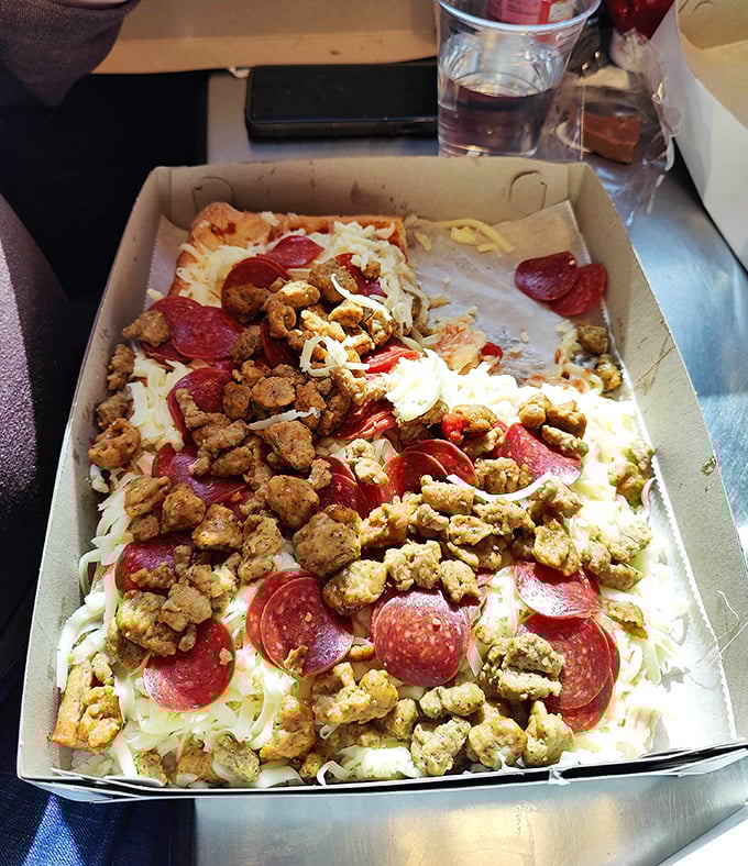 Pizza maximalism at its finest—pepperoni and sausage creating a meaty mosaic atop that signature cold cheese mountain. This isn't a topping situation; it's a topping celebration.
