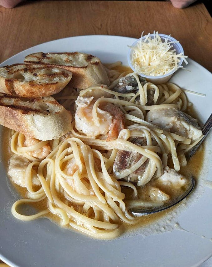Seafood pasta that makes you wonder why anyone eats noodles without shellfish. Those shrimp aren't just swimming in sauce—they're doing the backstroke in flavor.