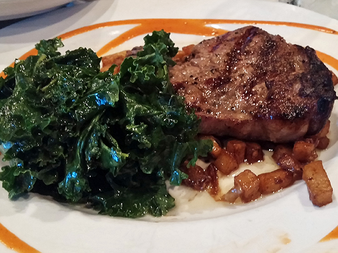 A perfectly seared steak nestled on greens – proof that sometimes dinner can be both virtuous and indulgent.