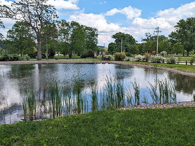 This serene park pond reflects more than clouds—it mirrors the peaceful pace that makes retirees toss their alarm clocks into yard sales.