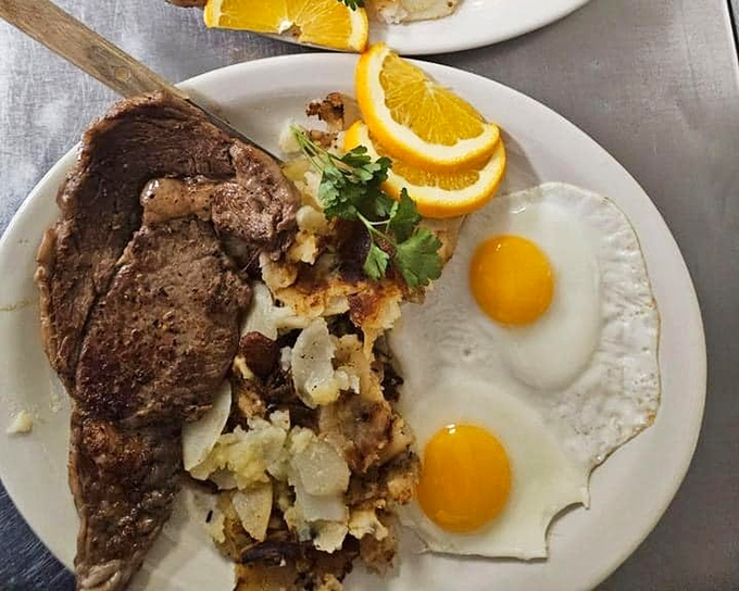 The breakfast trifecta—perfectly seared steak, sunny-side-up eggs, and crispy potatoes create the kind of plate that makes you seriously reconsider brunch reservations elsewhere.