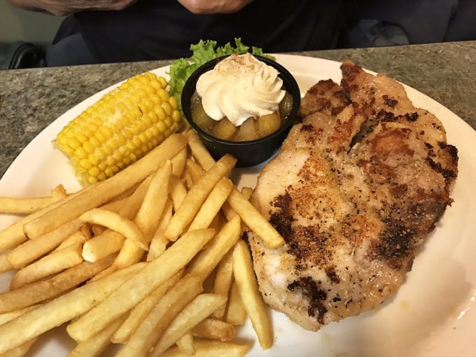 This isn't just dinner, it's edible architecture – golden pork chop, crispy fries, and corn on the cob creating the comfort food trifecta that dreams are made of.