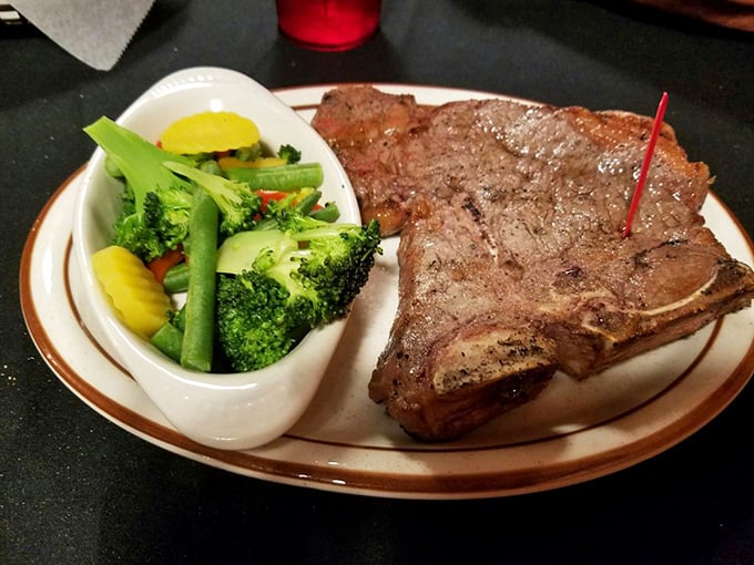 The T-bone: where filet mignon meets strip steak in meaty matrimony. Those vegetables aren't just garnish—they're there to ease your conscience.