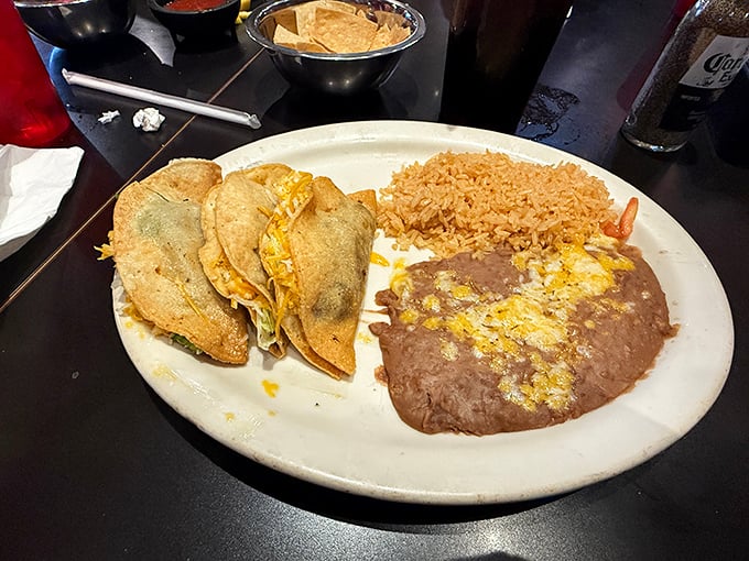 Crispy tacos arranged like soldiers guarding their treasure of seasoned fillings. The rice and beans aren't sidekicks—they're co-stars in this production.