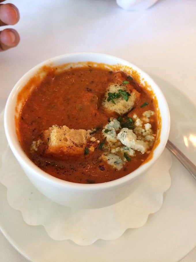 This isn't just tomato bisque—it's a warm hug in a bowl, complete with blue cheese crumbles playing the delicious supporting role.